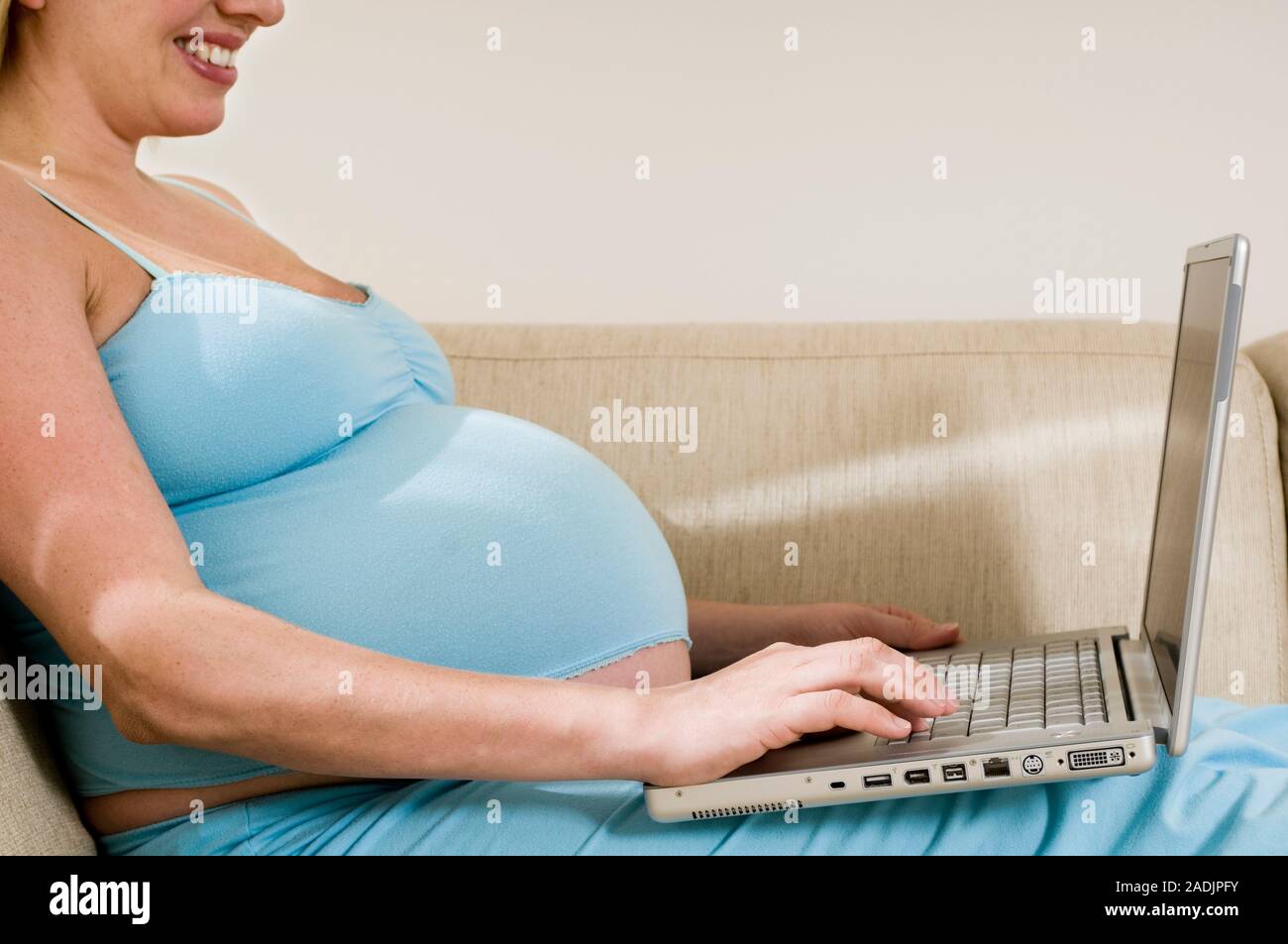 MODEL RELEASED. Heavily pregnant woman using a laptop computer Stock ...