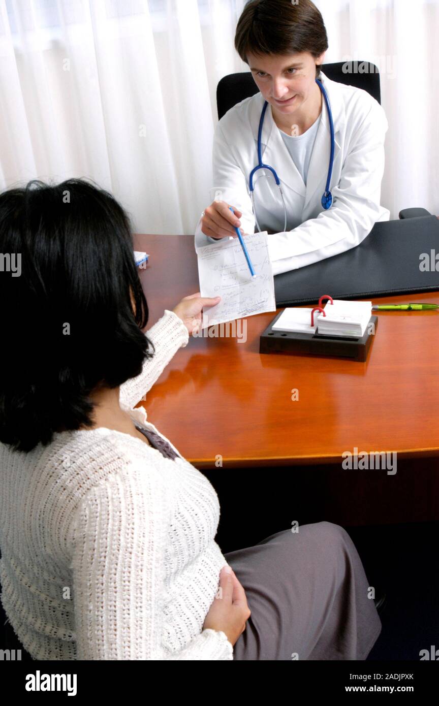 MODEL RELEASED. Obstetric consultation. Doctor handing out a ...