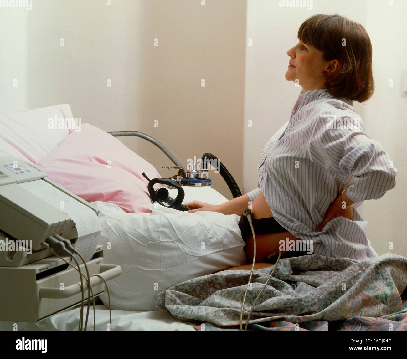 Foetal monitoring during labour. Woman in early labour attached to a ...