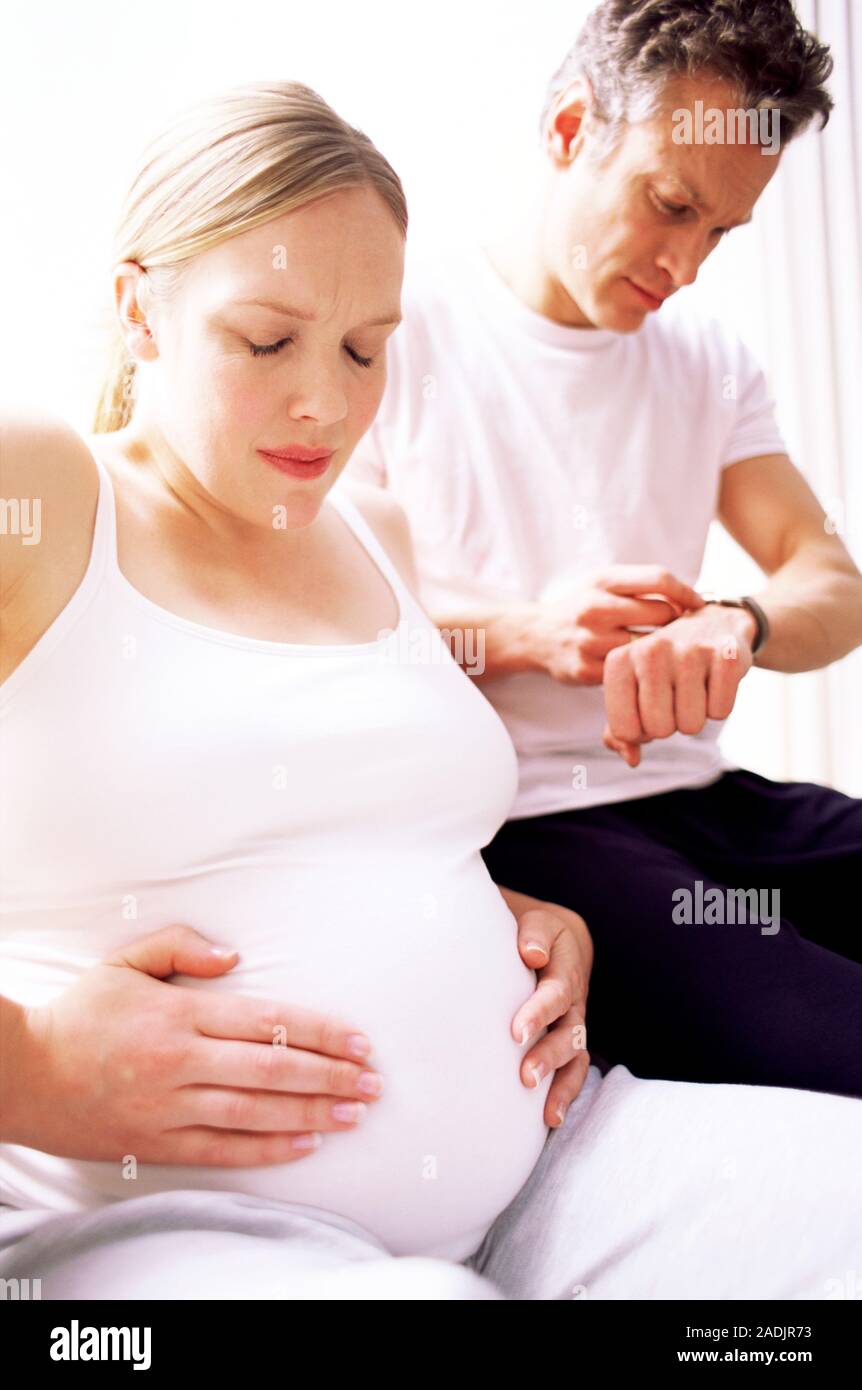 MODEL RELEASED. Timing contractions. Man timing contractions of his ...