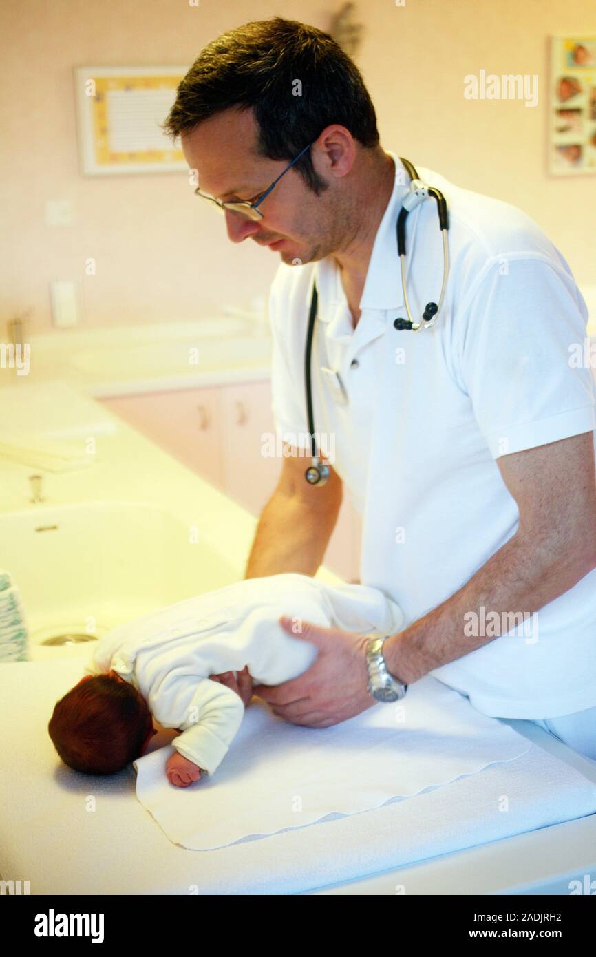 Neonatal reflex test. Paediatrician testing a newborn baby's crawl ...