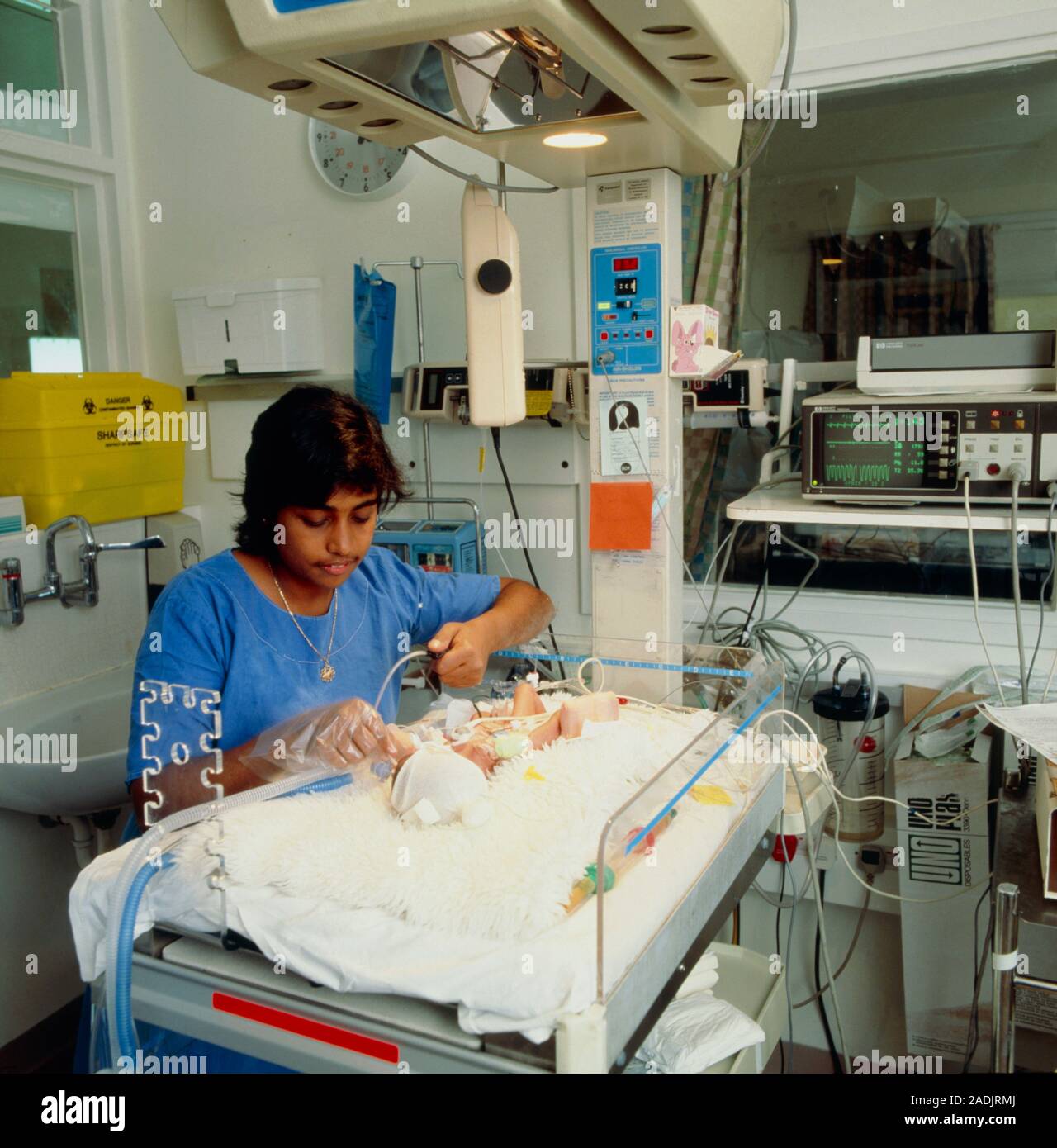 Neonatal infant being attended by a nurse in intensive care Stock Photo ...