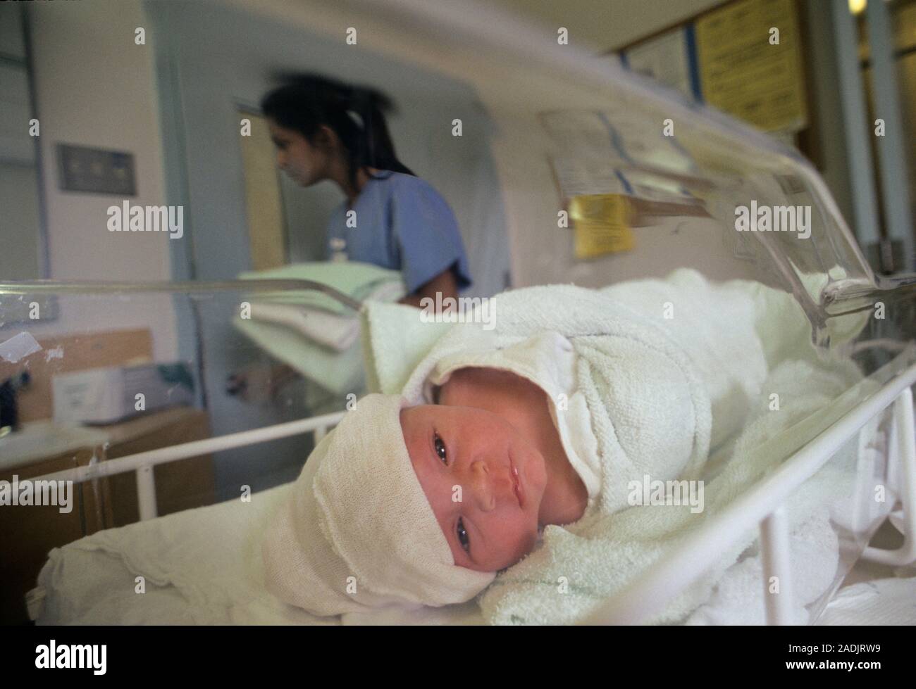 Newborn baby in an incubator. The incubator provides the baby with ...