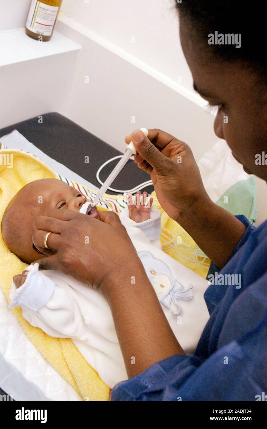 MODEL RELEASED. Premature baby. Mother using a dropper to give water to ...