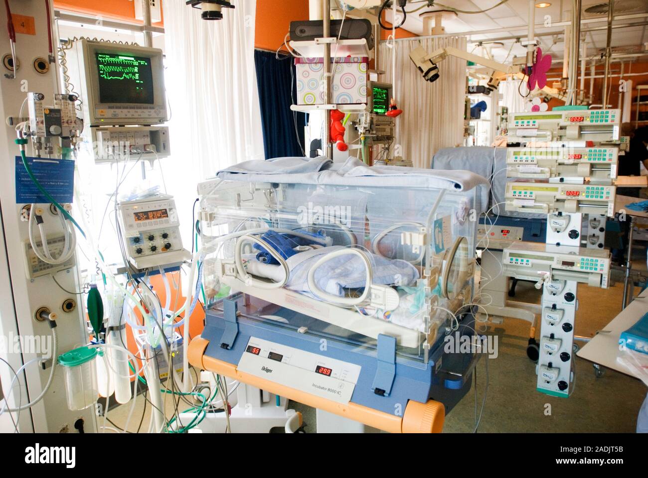 Premature baby ward. Premature baby in an incubator, surrounded by ...