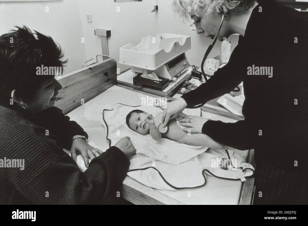 Paediatric examination. Doctor using a stethoscope to monitor the heart ...