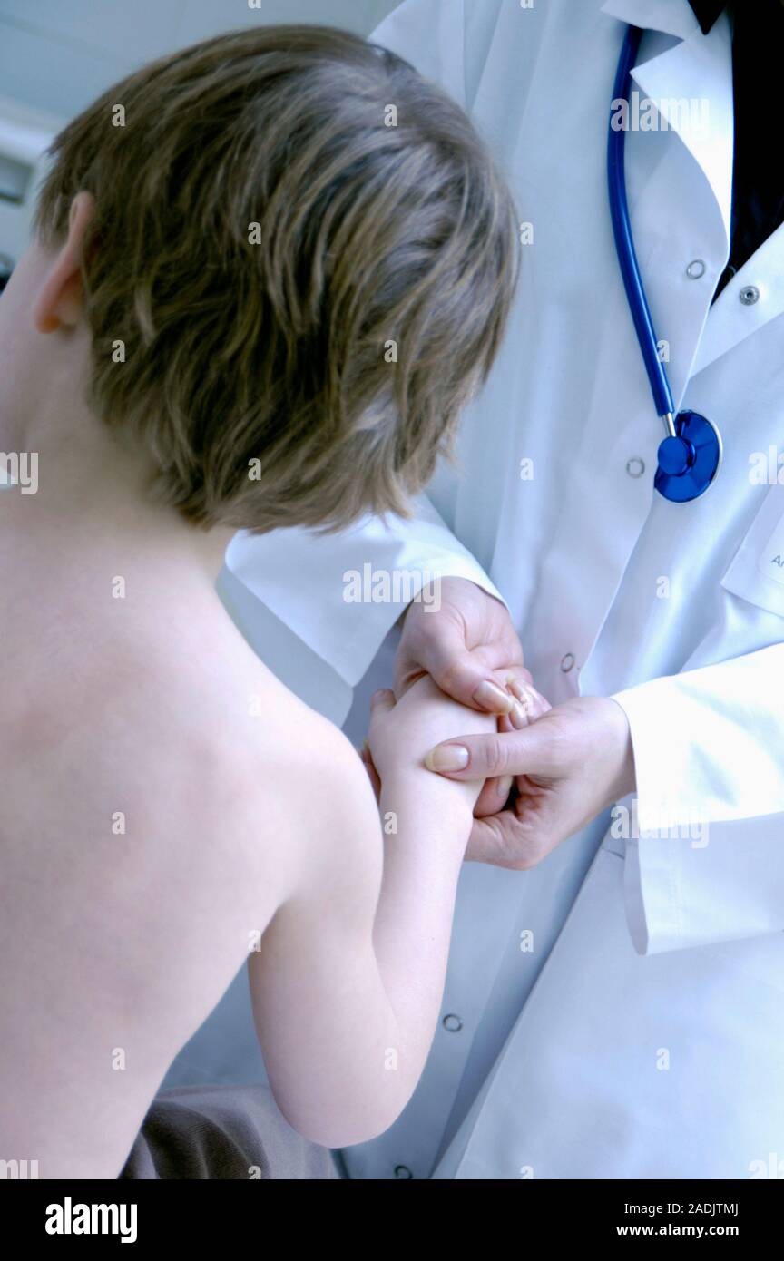 MODEL RELEASED. Paediatric examination. Paediatrician examining a young ...