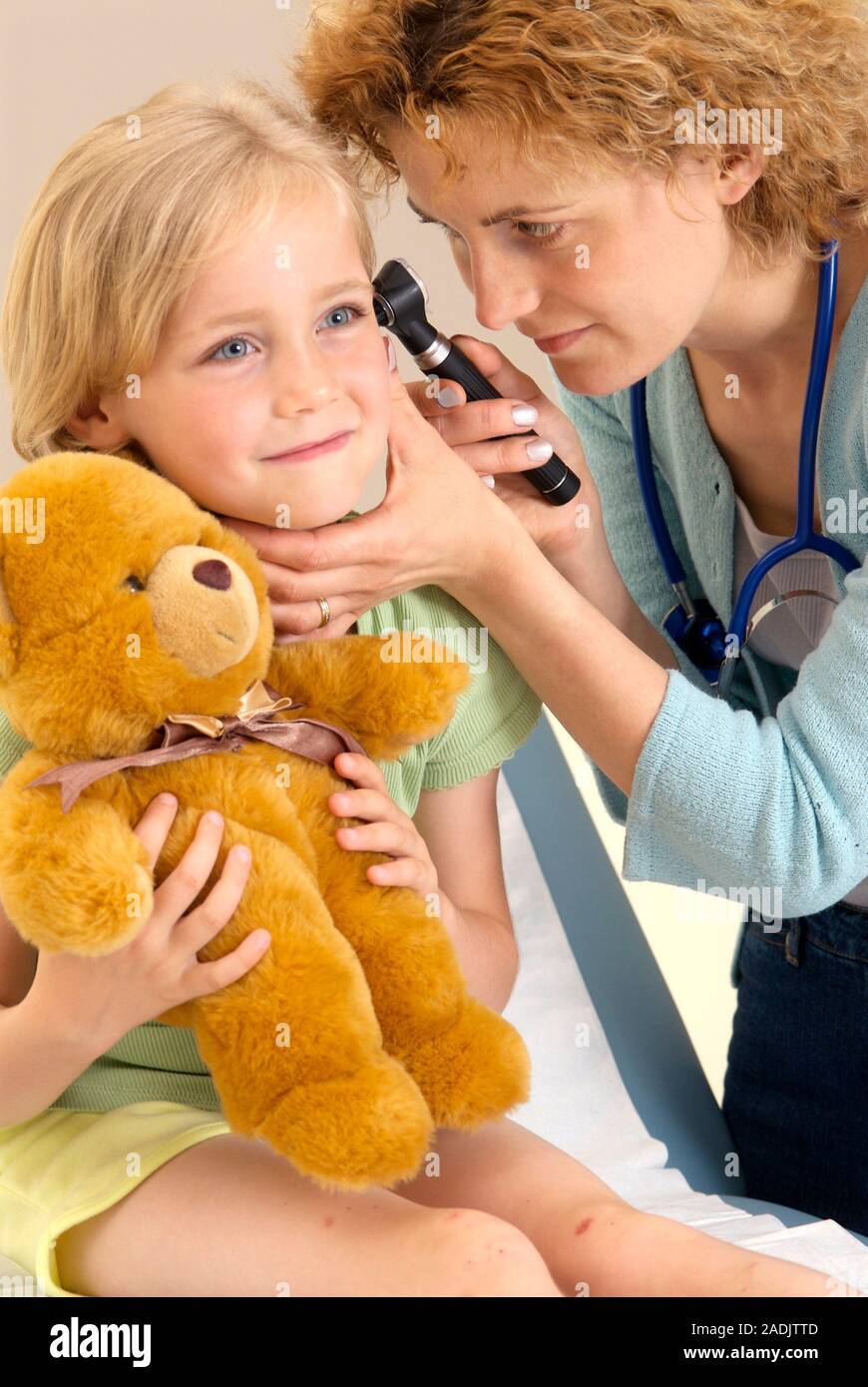 MODEL RELEASED. Ear examination. Paediatrician using an otoscope to ...