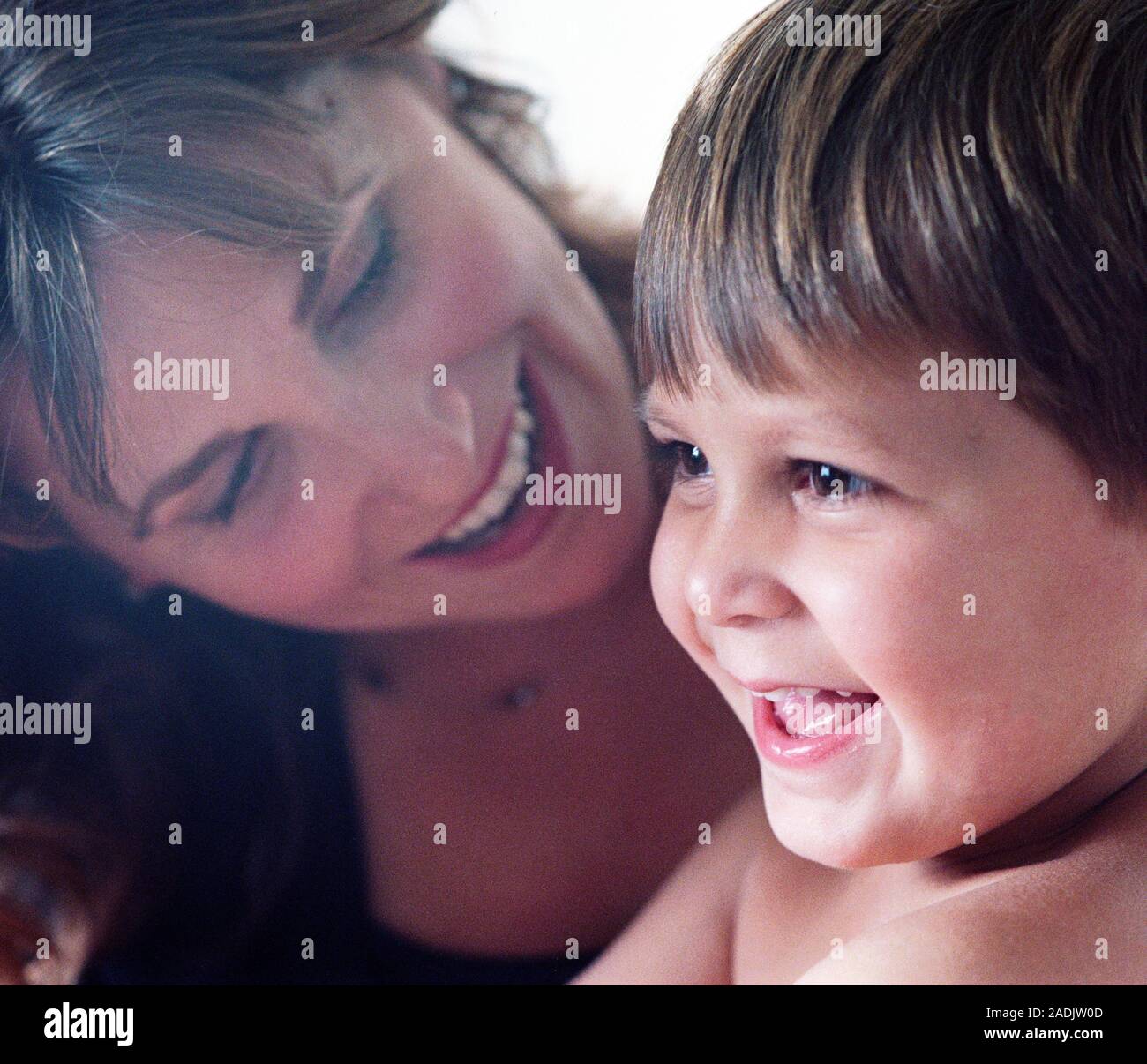 Child care. Smiling boy being watched by his mother Stock Photo - Alamy