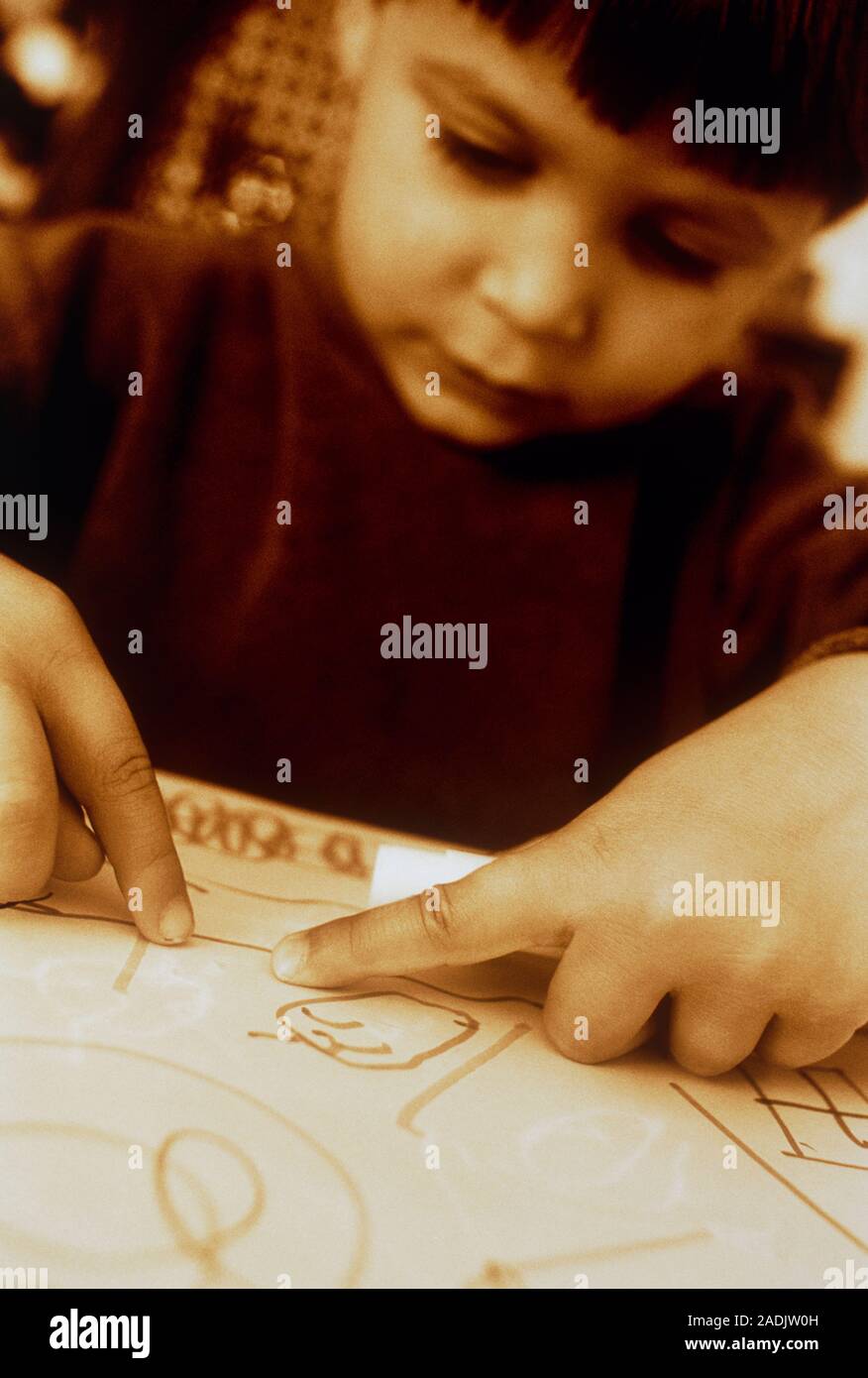 Boy with drawing. Young boy tracing the lines of his drawing with his ...