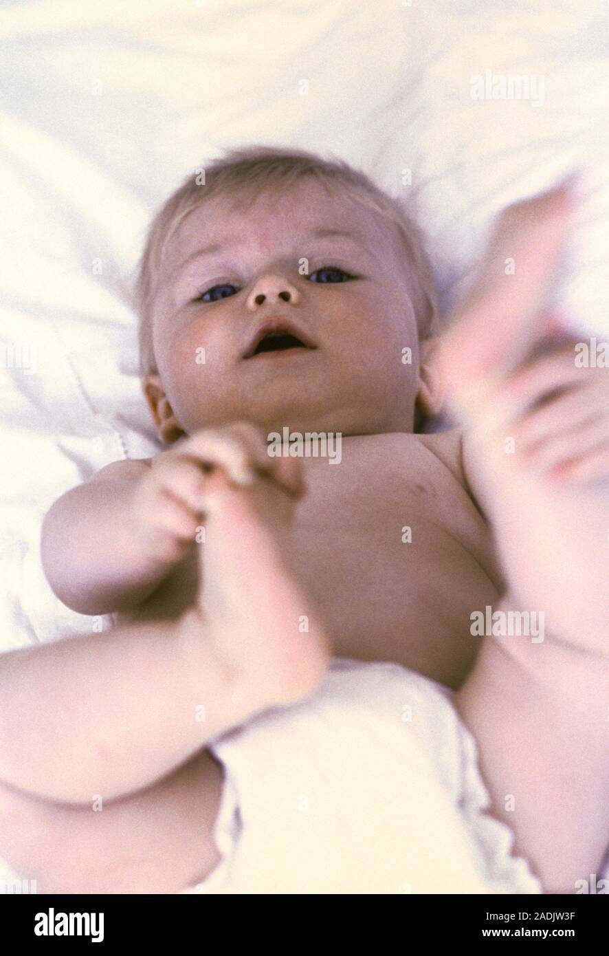 Baby. Seven-month-old baby boy wearing a nappy and lying on a bed Stock ...