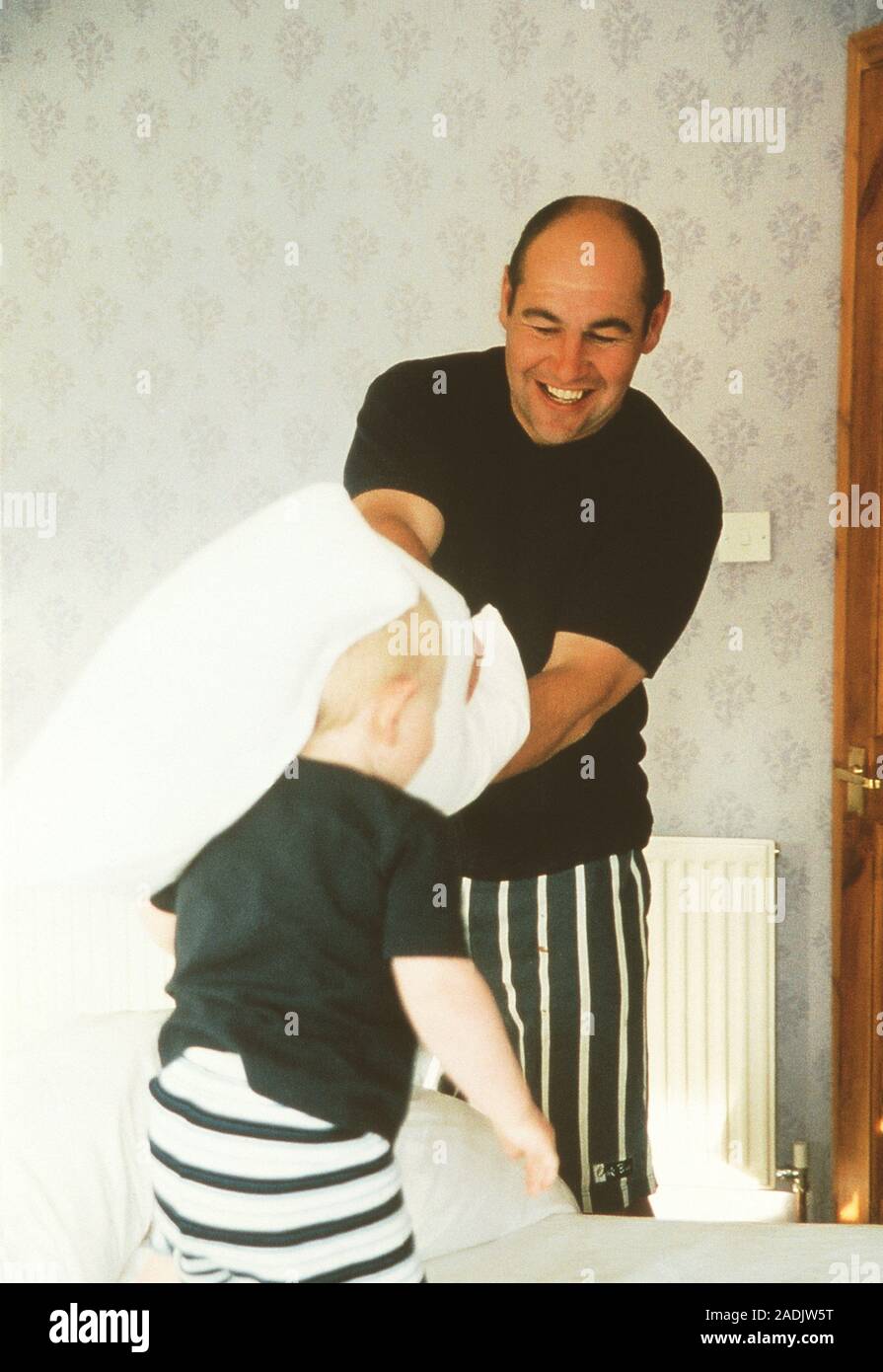 Pillow-fight. Father hitting his baby son playfully with a pillow Stock ...