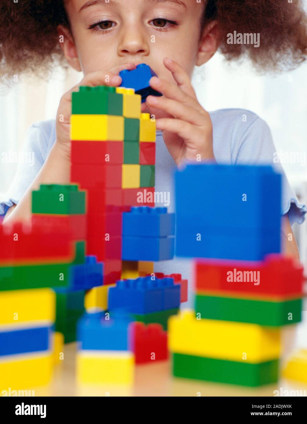 MODEL RELEASED. Girl playing with lego. Three year old girl building ...
