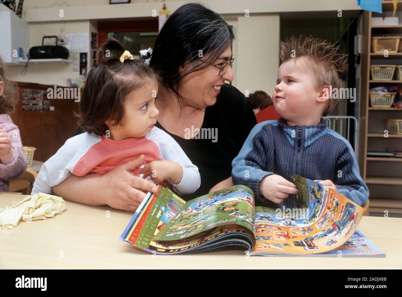 Child care at a children's day care centre. Day care assistant looking ...