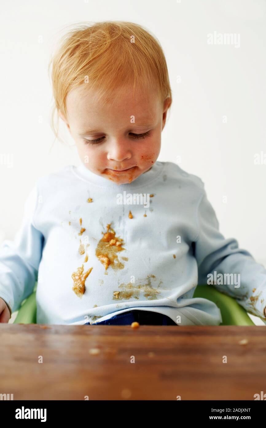 MODEL RELEASED. Messy child eating his food. He is eighteen months old ...