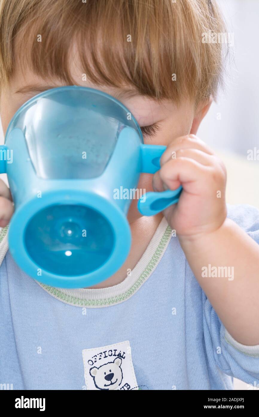 MODEL RELEASED. Toddler drinking from a beaker Stock Photo - Alamy