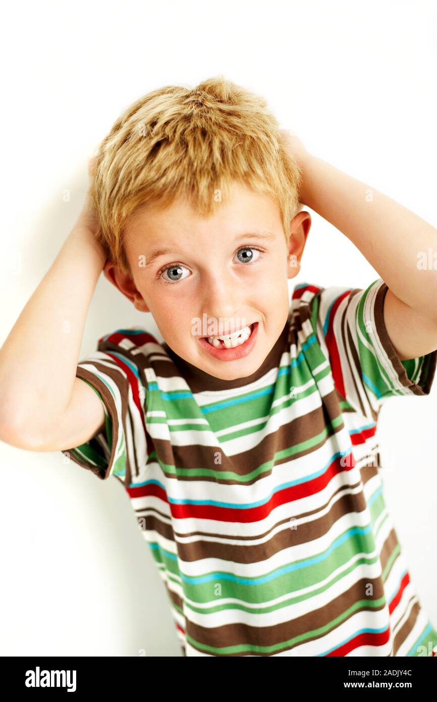 MODEL RELEASED. Head lice. Boy scratching head to relieve the itchy ...