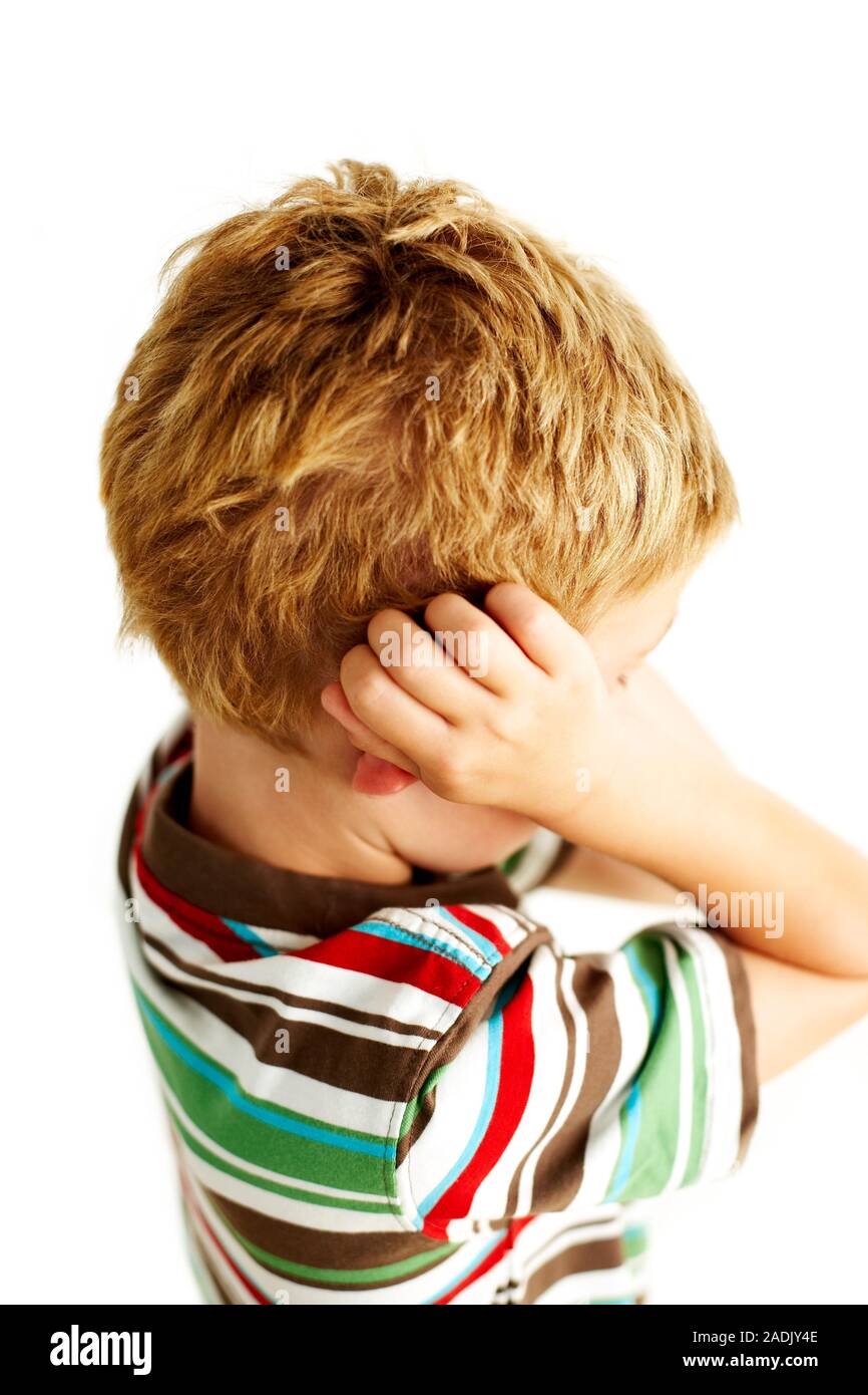 MODEL RELEASED. Head lice. Boy scratching head to relieve the itchy ...