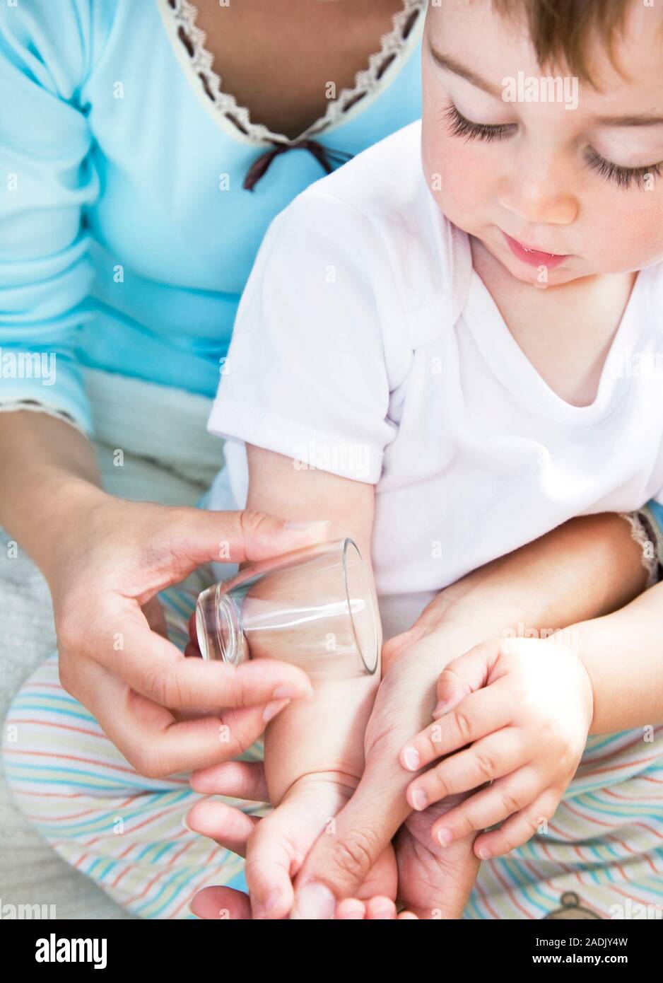 MODEL RELEASED. Meningitis and septicaemia test. Mother performing the ...