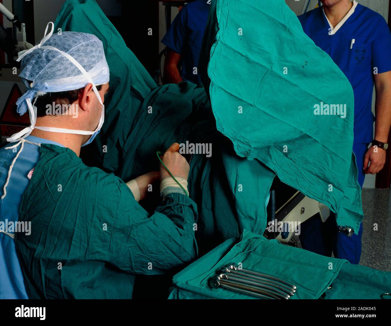 Surgeon performing a gynaecological operation known as dilatation ...