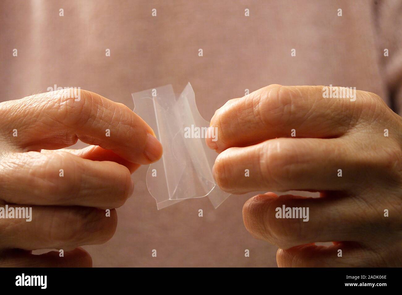 Hormone replacement therapy (HRT) patch about to be put on skin. This ...