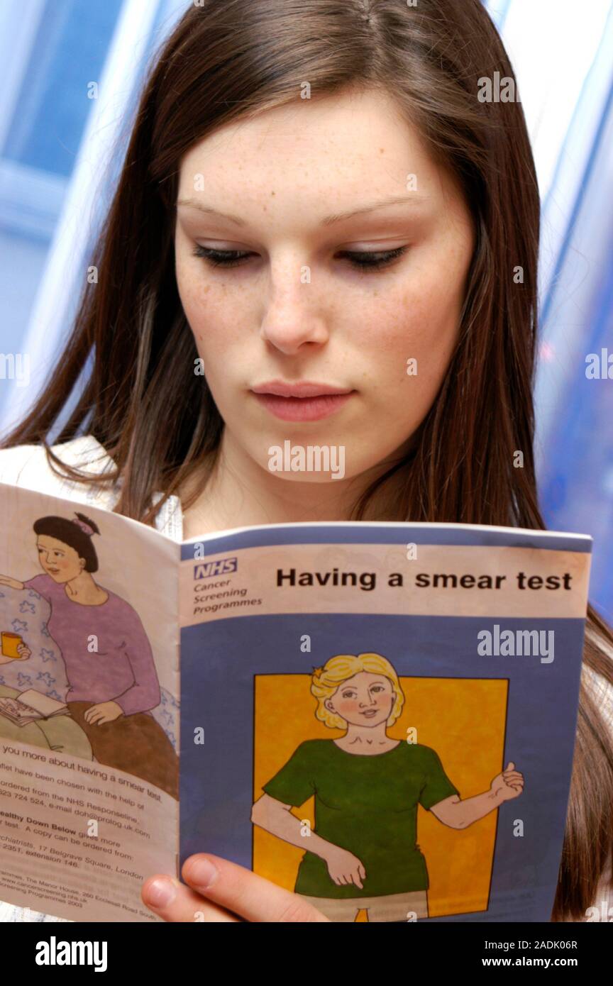 MODEL RELEASED. Cervical smear information. Woman reading a NHS leaflet ...