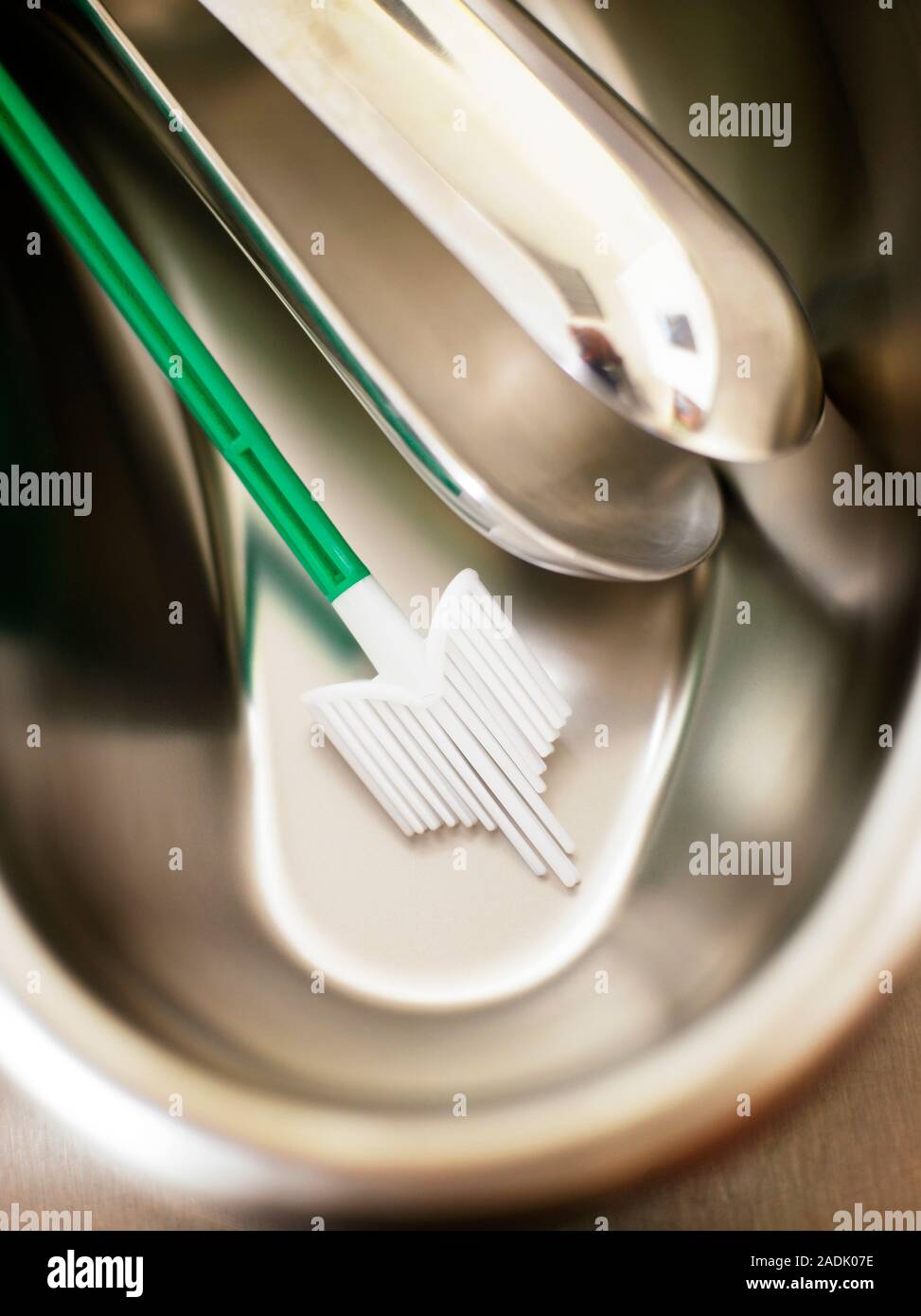 Smear test equipment. Tip of a duck-billed speculum and cytobrush in a ...