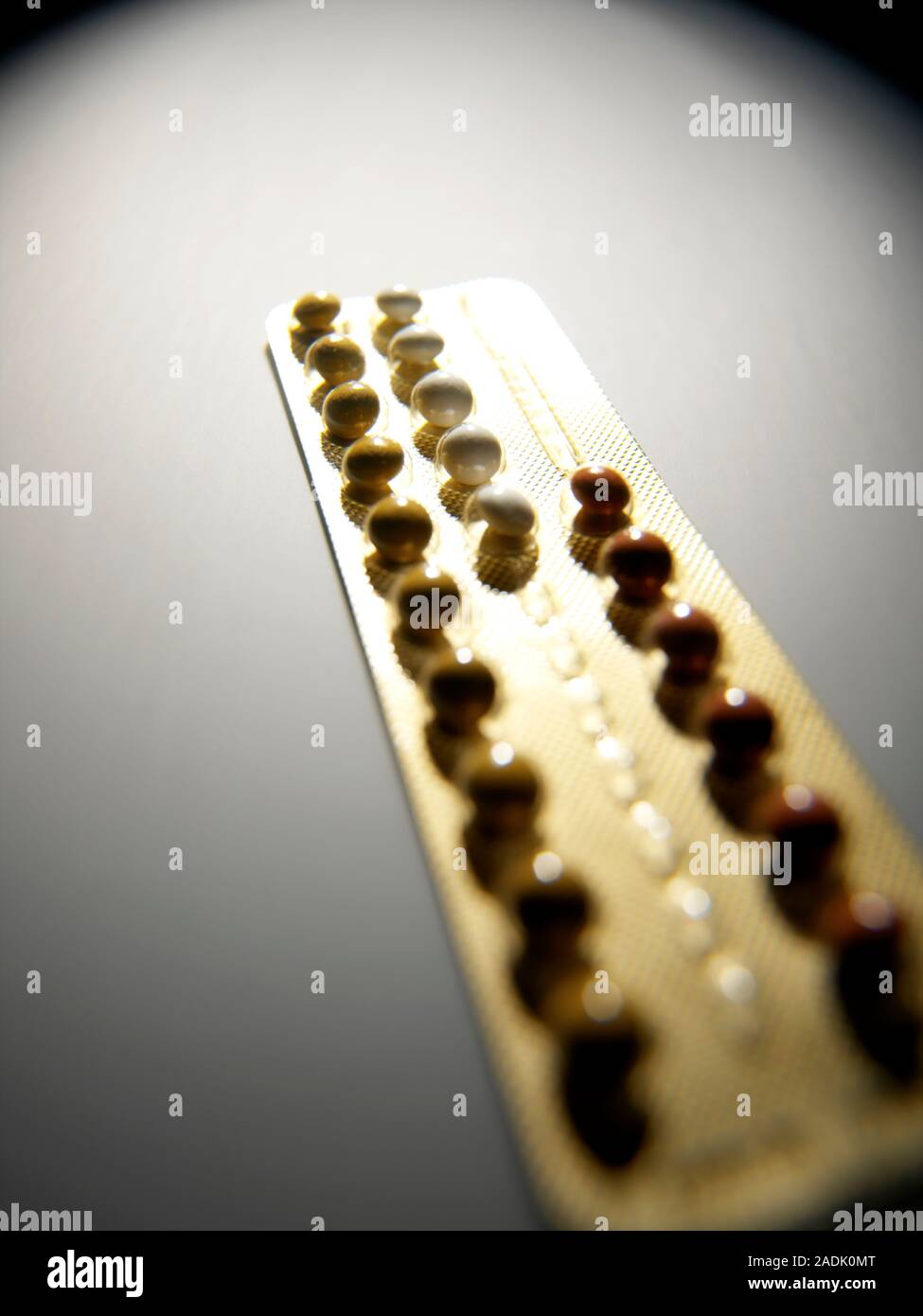 Oral contraception. Packet of contraceptive pills beneath light. These ...