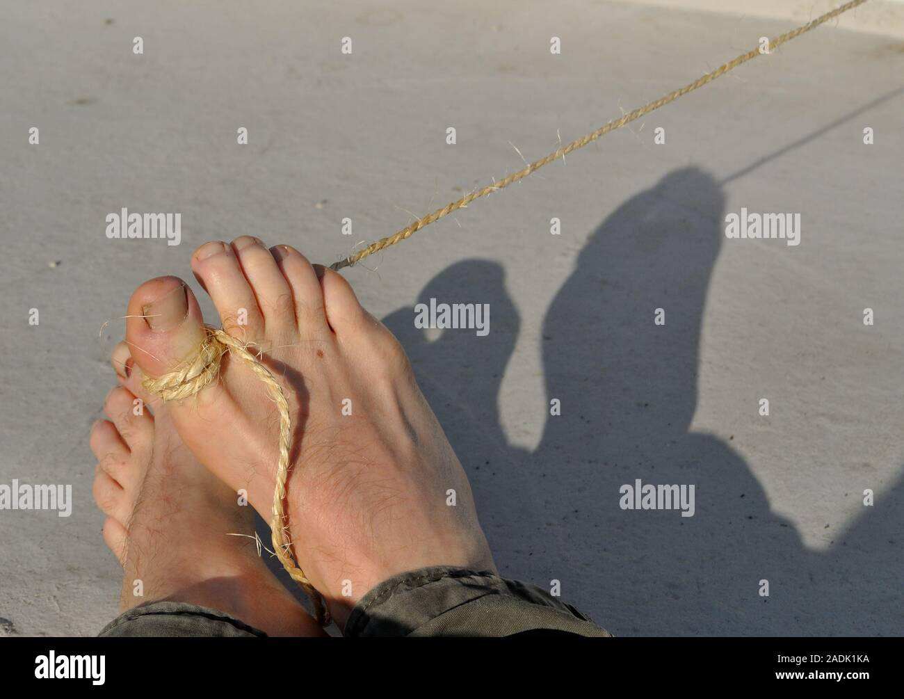 A big toe on the foot of a Caucasian male towing a line in a visual pun ...