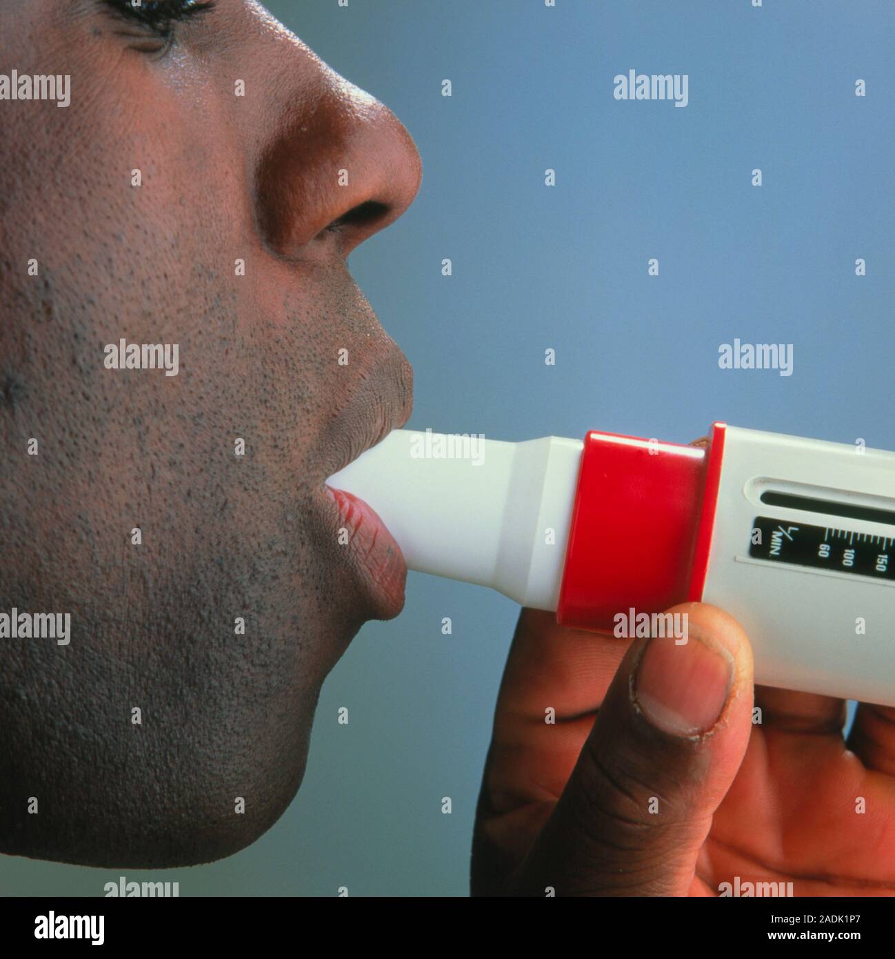 MODEL RELEASED. Lung function test. Man breathing out through a peak ...