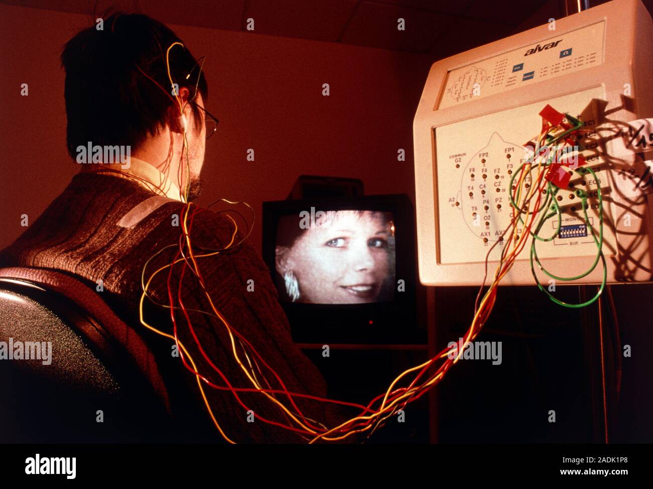Memory testing. Subject watches a TV screen with wires connecting his ...