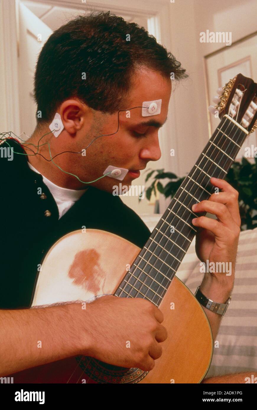 Circadian rhythm experiment. Male subject plays the guitar late at ...