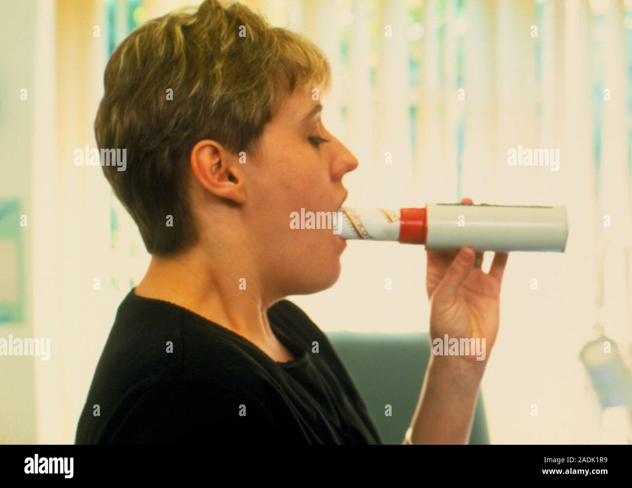 Lung function test. Woman preparing to breathe out through a peak flow ...