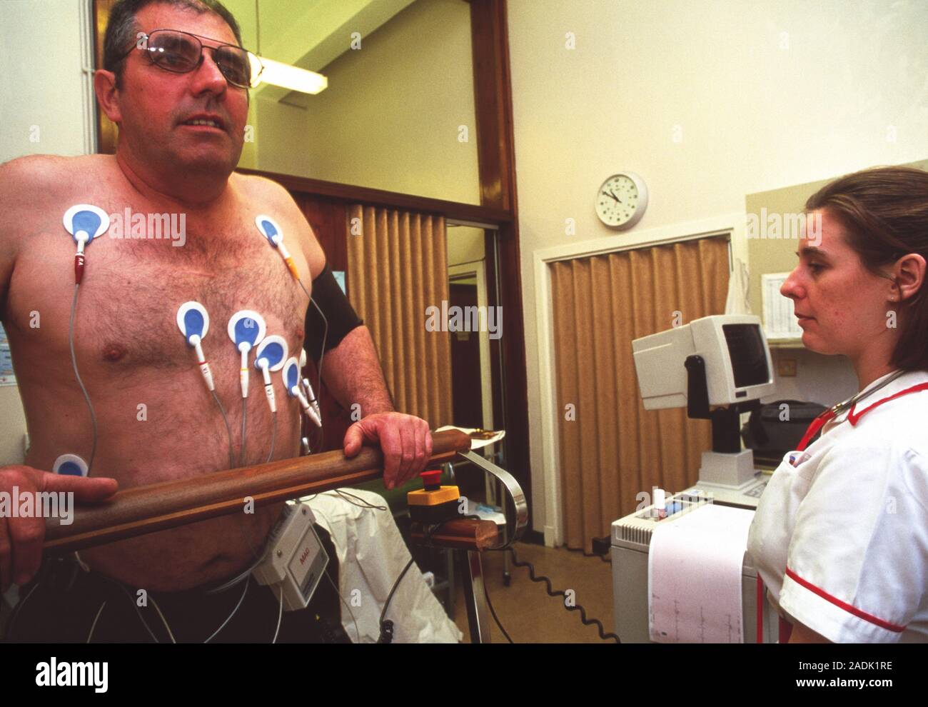 Stress test. Nurses monitoring a patient performing exercise during a ...