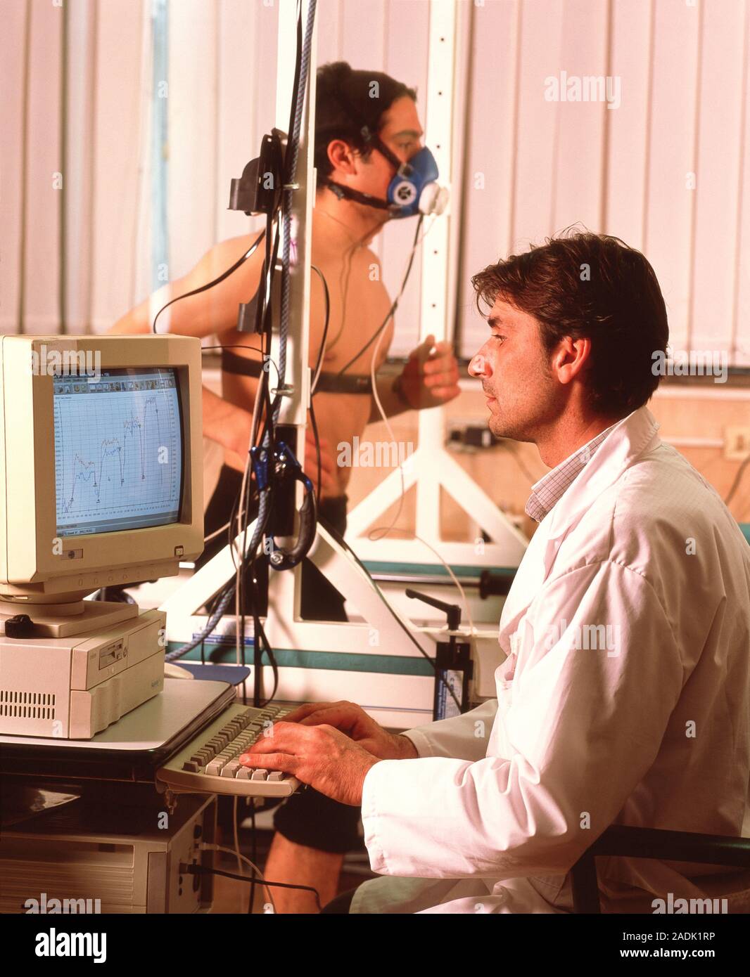 Fitness test. Doctor assessing the fitness of a male athlete running on ...