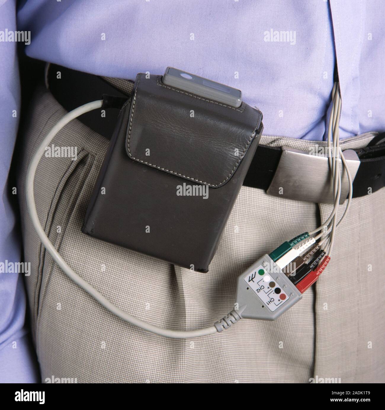 Heart monitor. Portable electrocardiograph on a man's belt. The wires ...