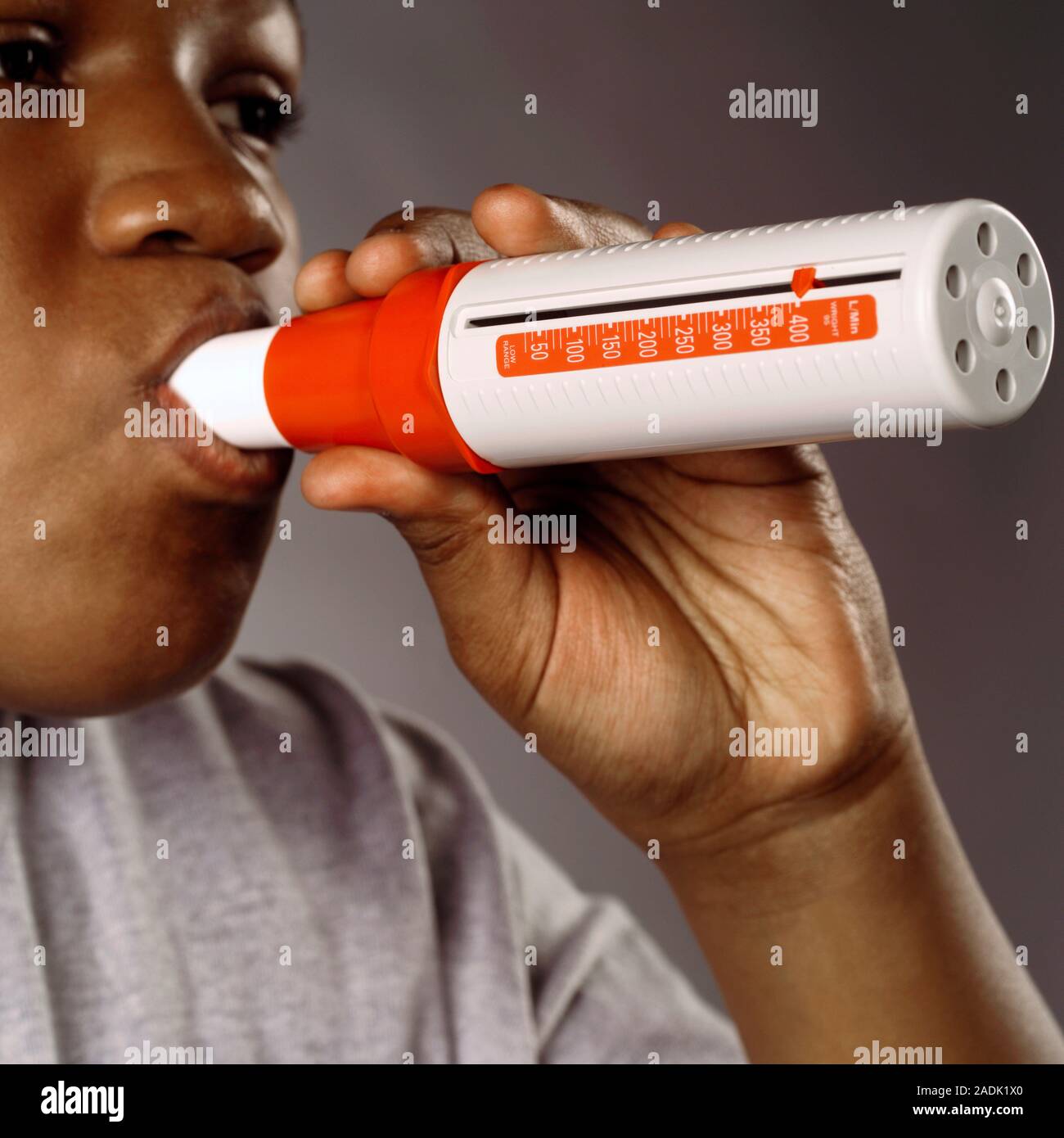 Lung function test. Boy breathing into a peak flow meter (spirometer ...