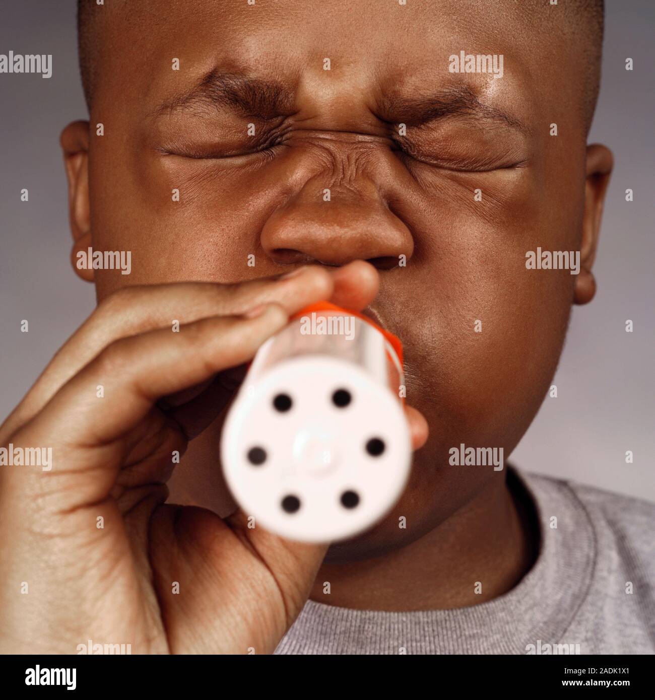 Lung function test. Boy breathing into a peak flow meter (spirometer ...