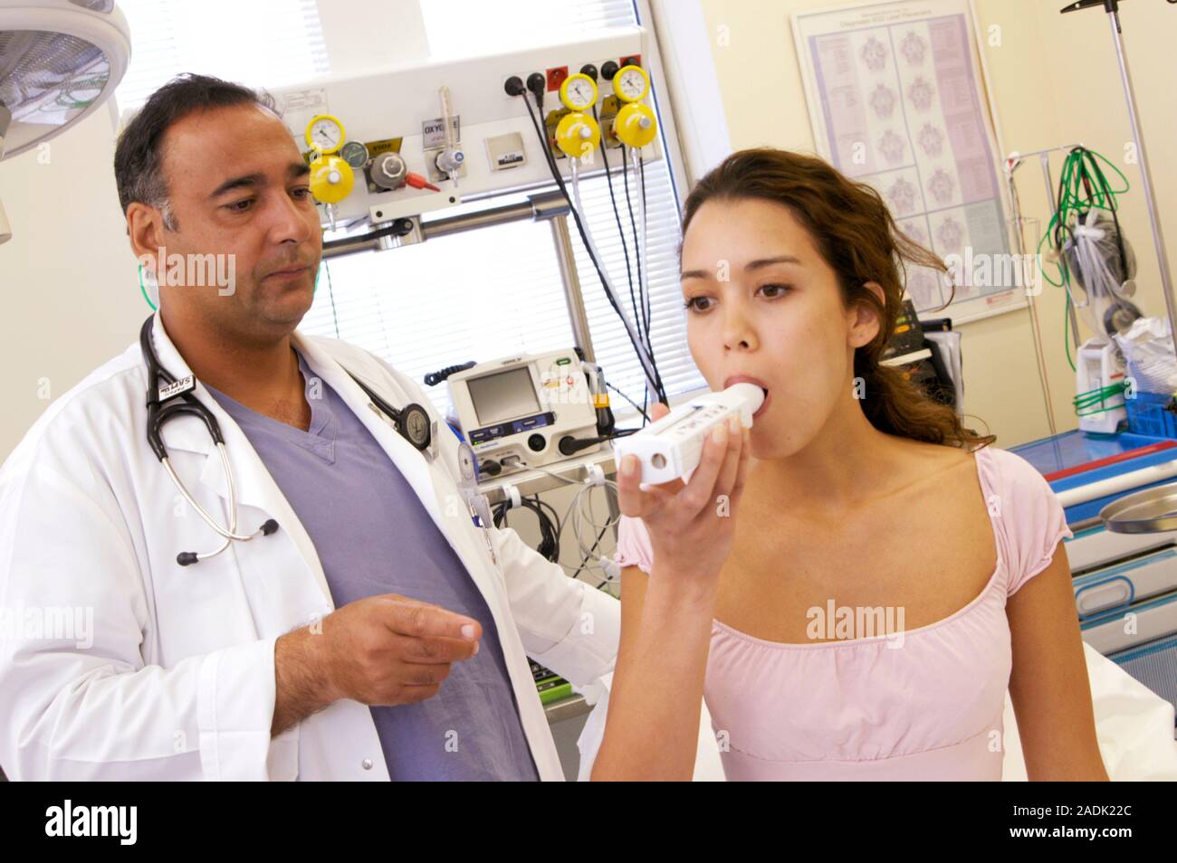 MODEL RELEASED. Lung function test. Doctor watching as a young woman ...