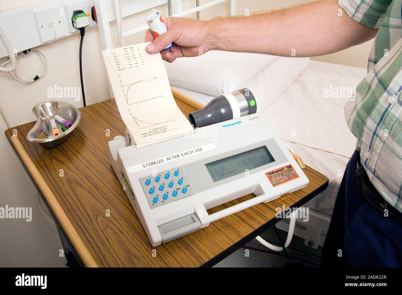 MODEL RELEASED. Lung function test results. Patient holds a spirometer ...