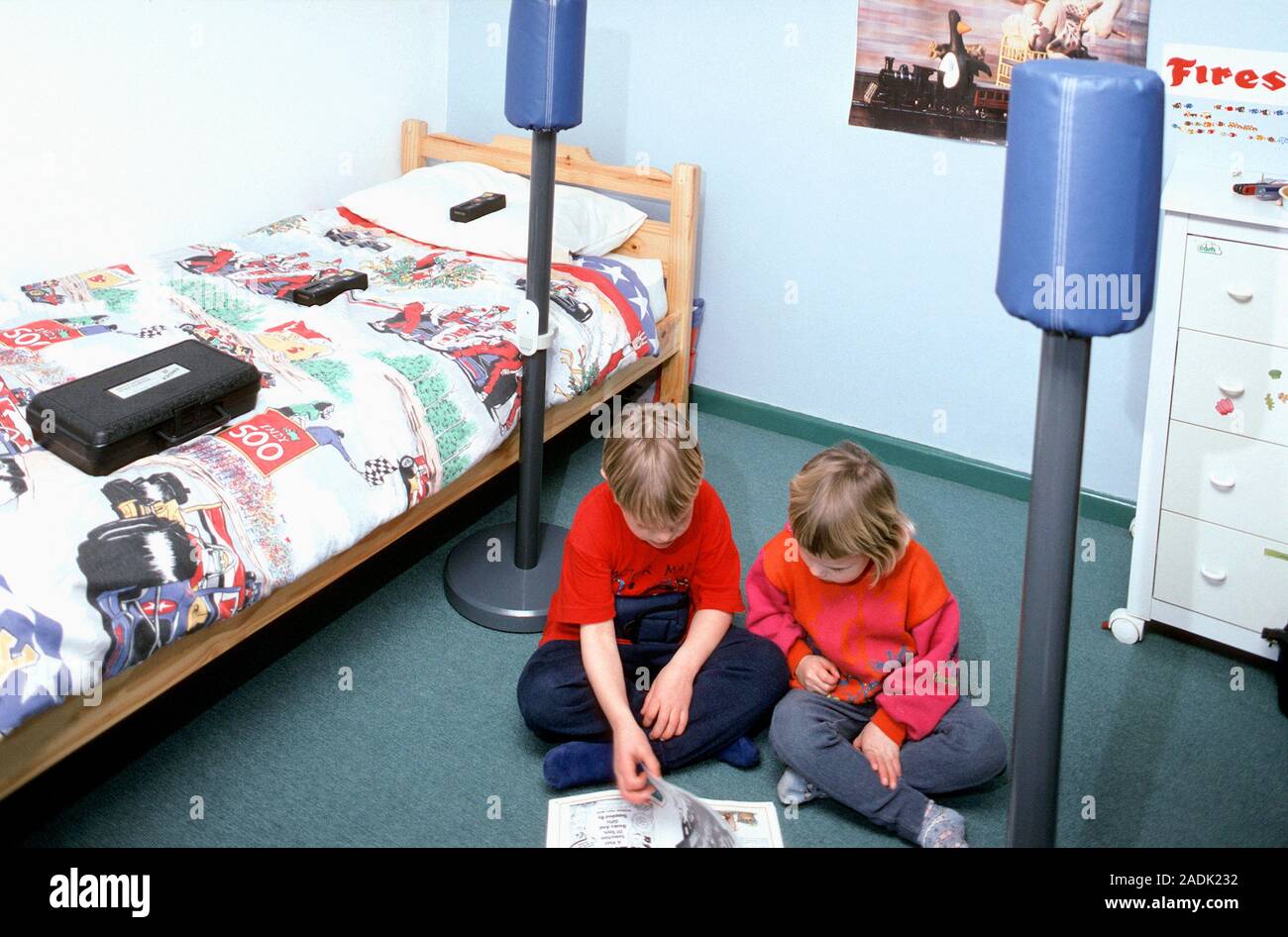 MODEL RELEASED. Electromagnetic field study. Two young children reading ...