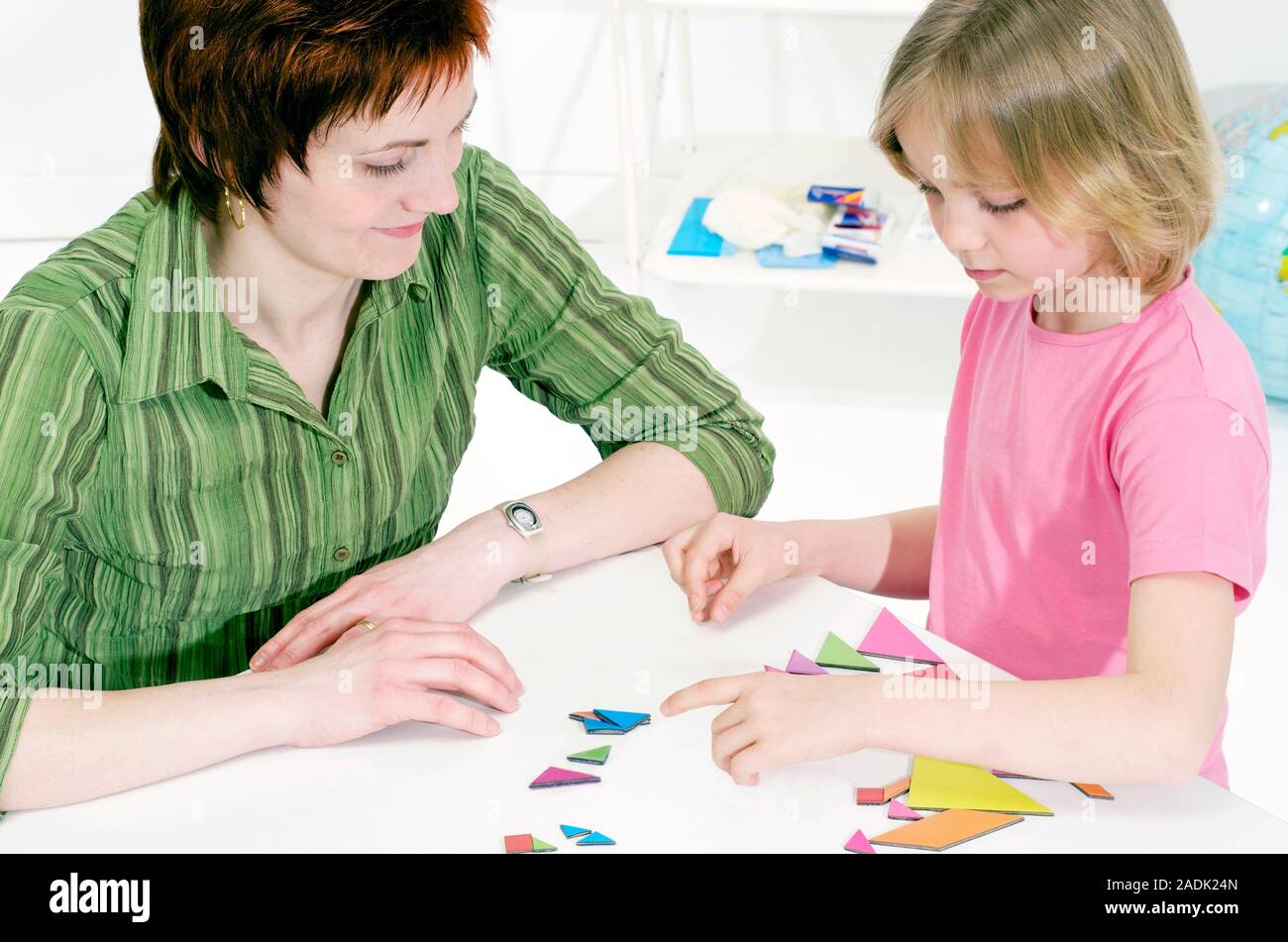 Logic game. Child psychologist with a girl who is playing a logic game ...