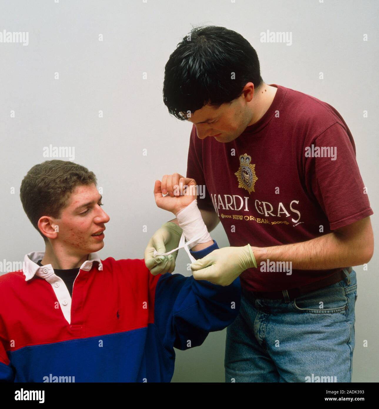 First aid for bleeding (image 3 of 3). Trainee first aider ties a ...