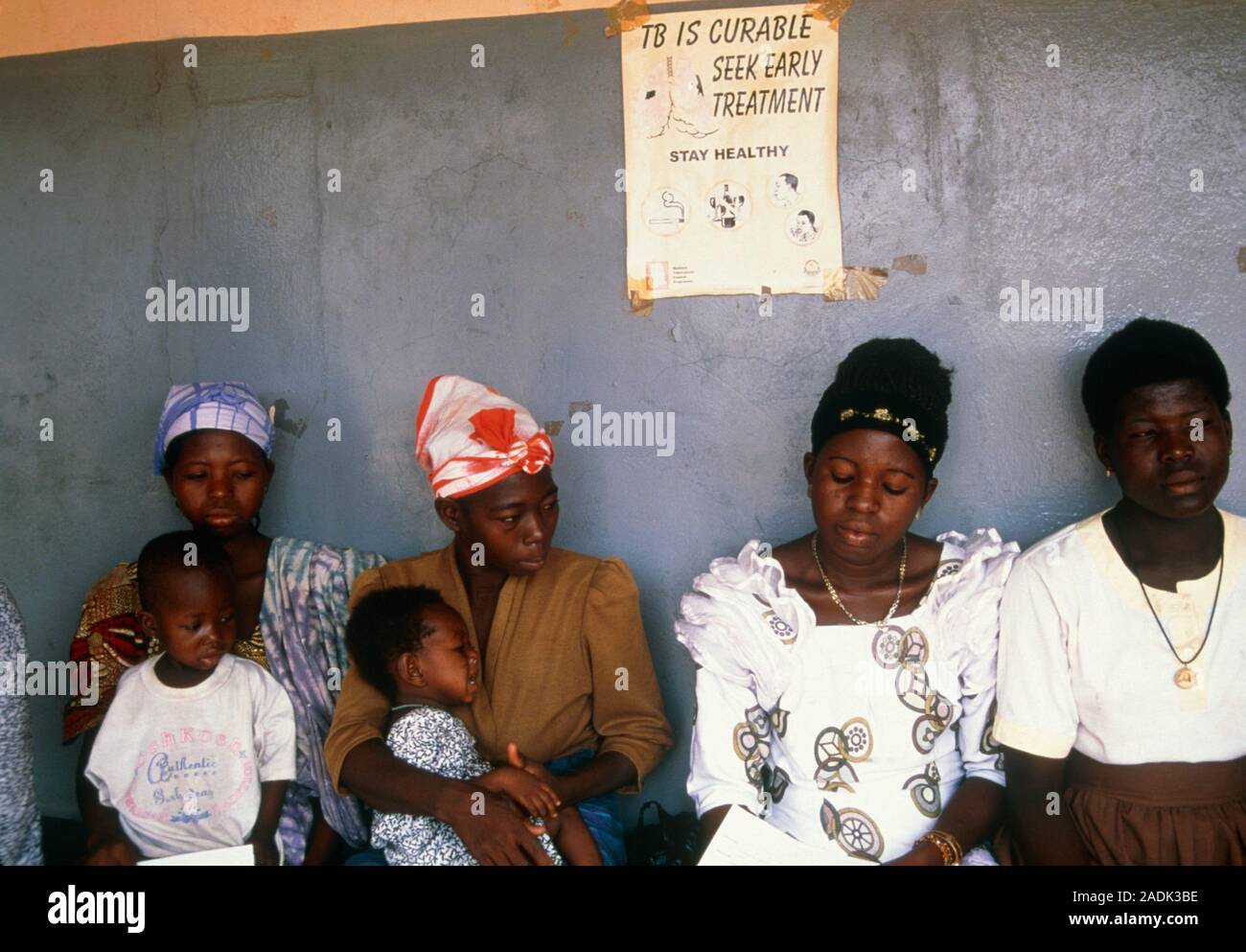 Tuberculosis education. Woman and children sitting beneath a health ...