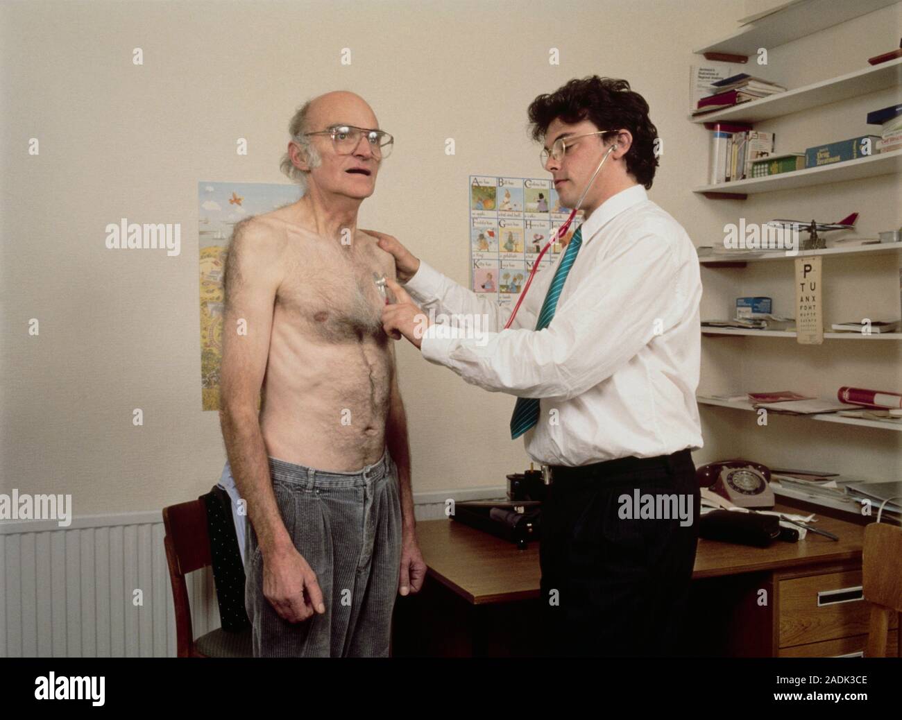 Doctor listening to the chest sounds of an elderly male patient using a ...