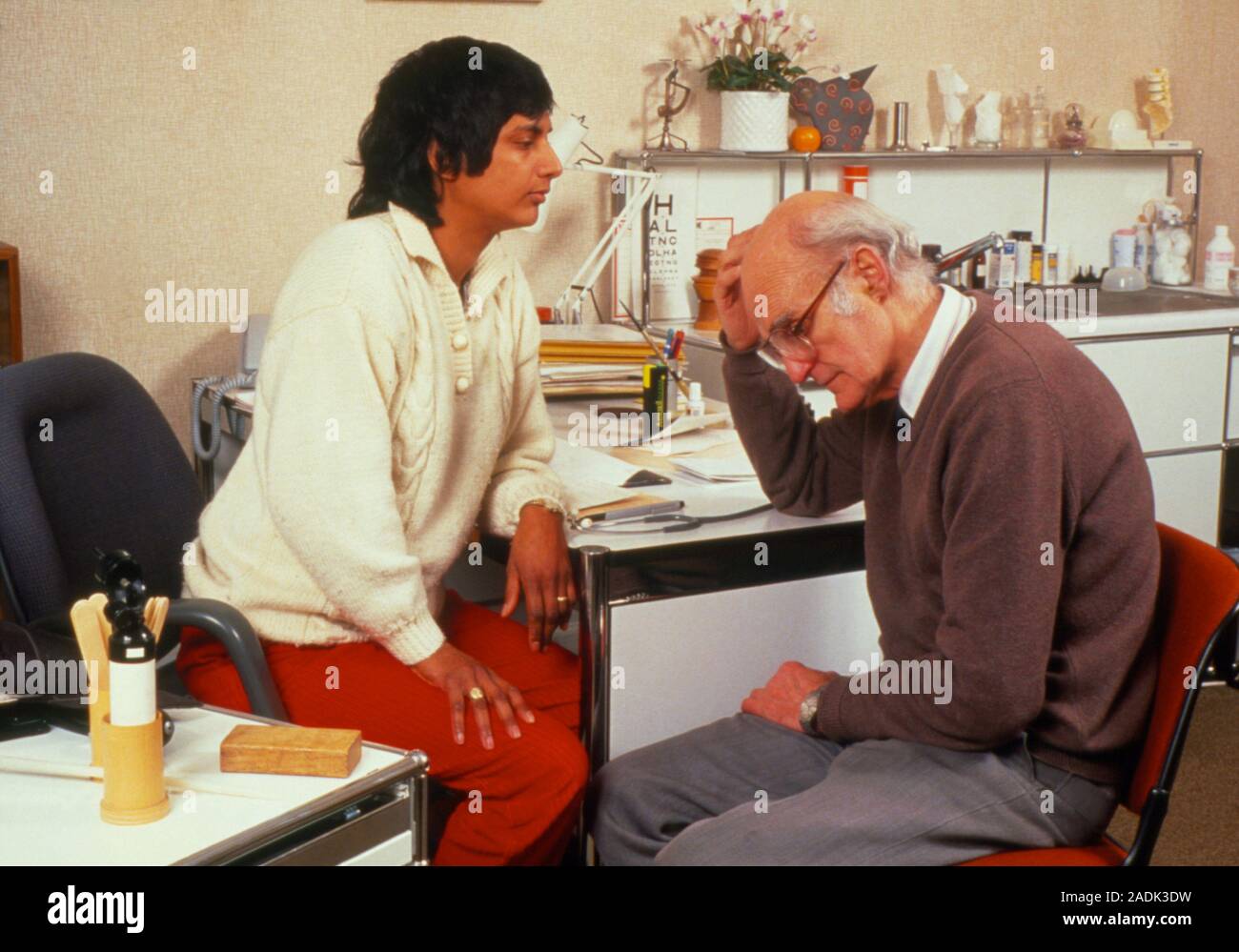 General practice doctor examining the scalp of a bald man. Baldness ...