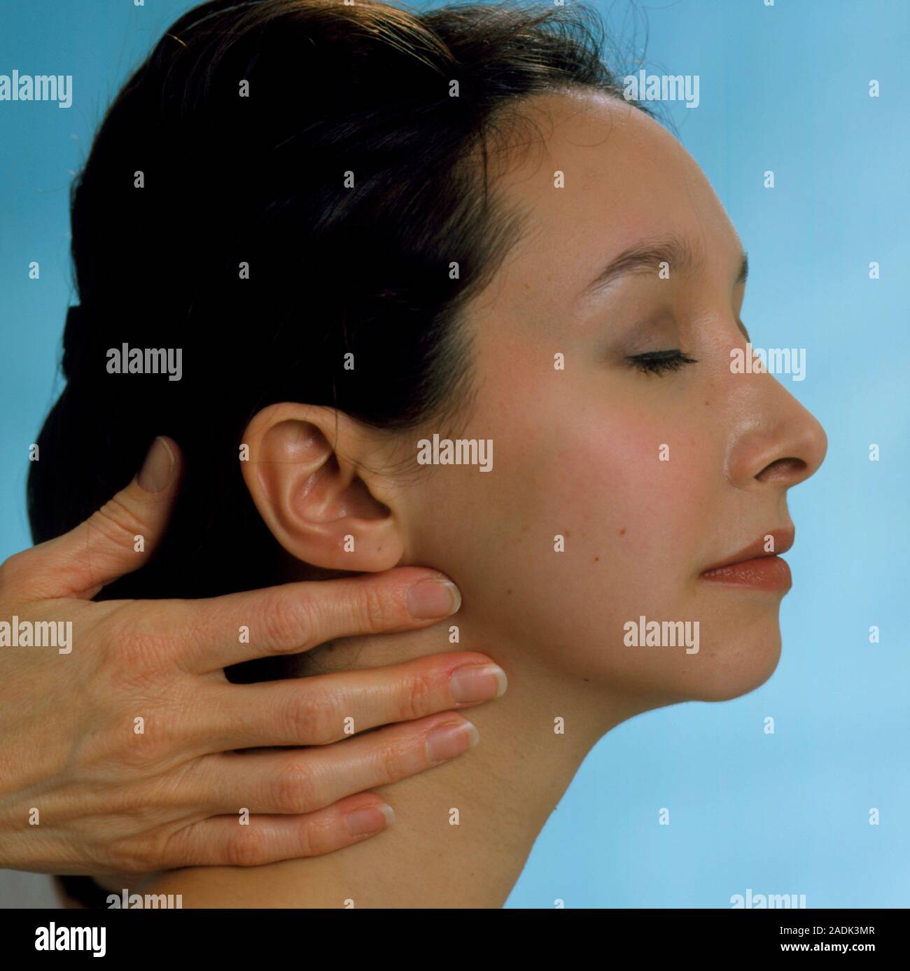 Neck examination. Young woman having her neck palpated by a general ...