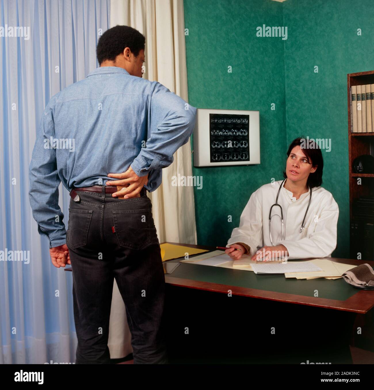 Back pain consultation. Man describes his symptoms of lower back pain ...