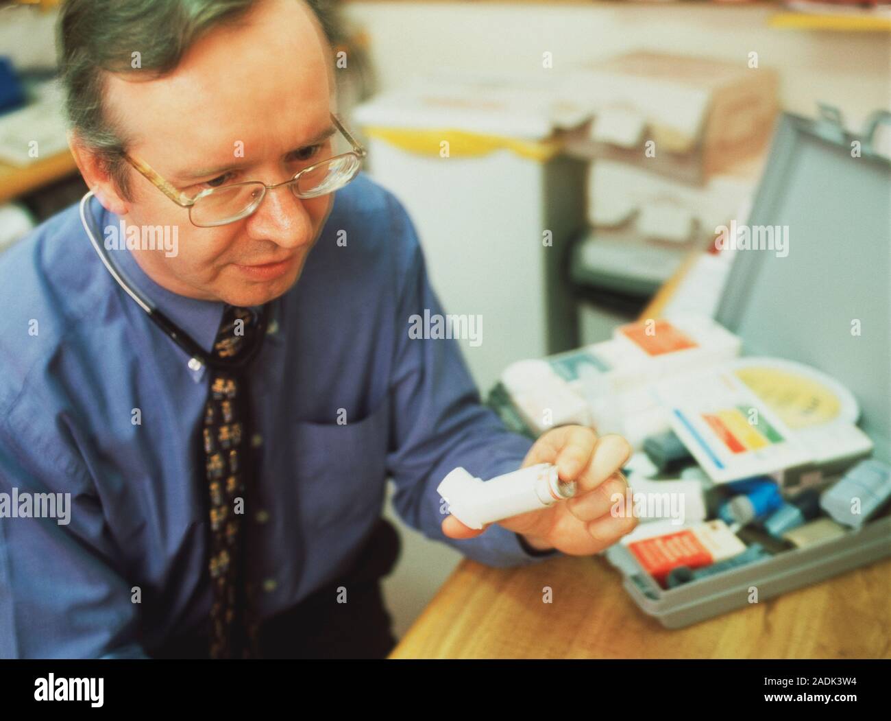 Consultation. Doctor demonstrating an asthma inhaler use to a patient ...
