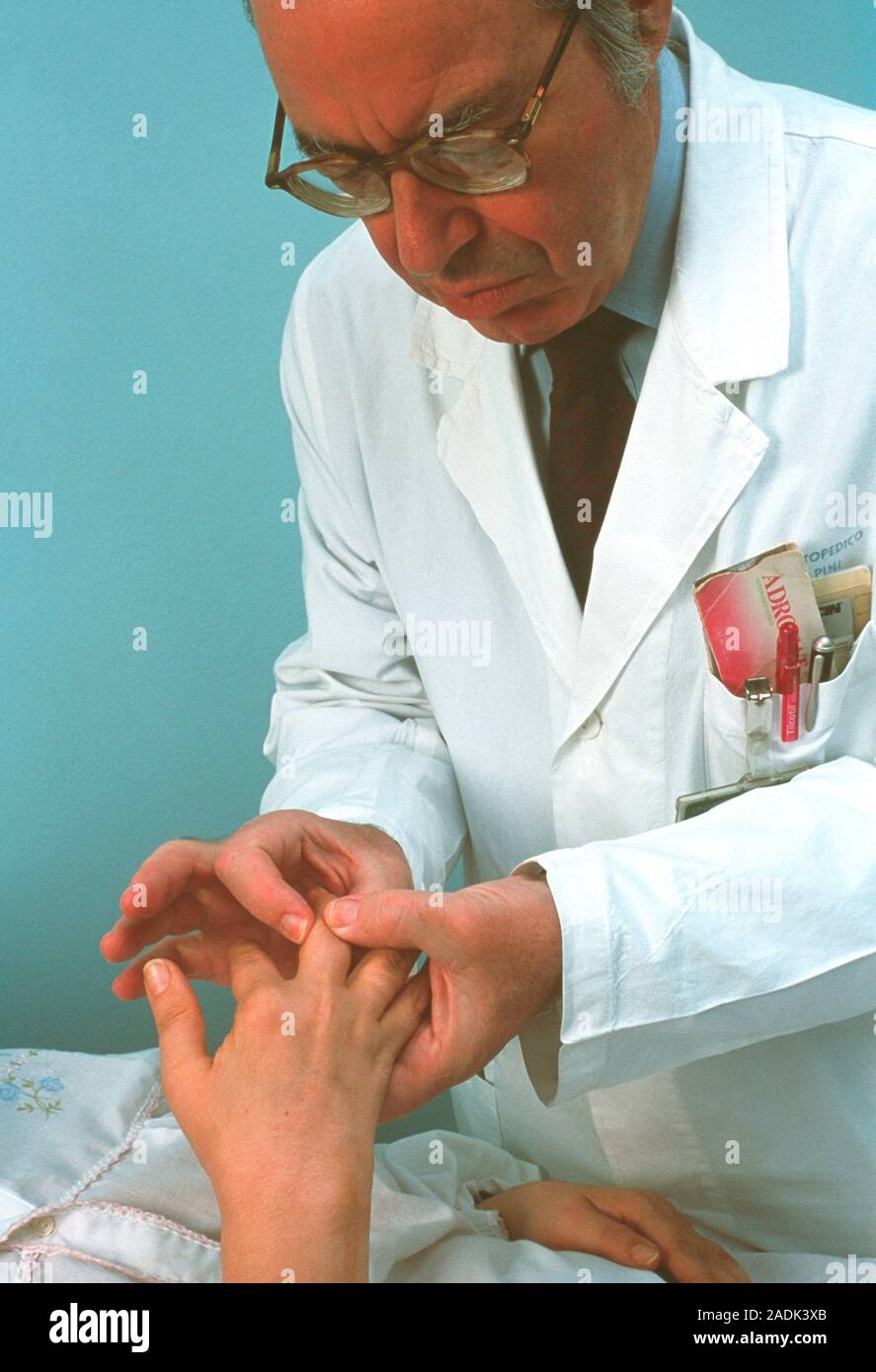 Hand examination. Doctor examining a patient's hand joints. Common ...